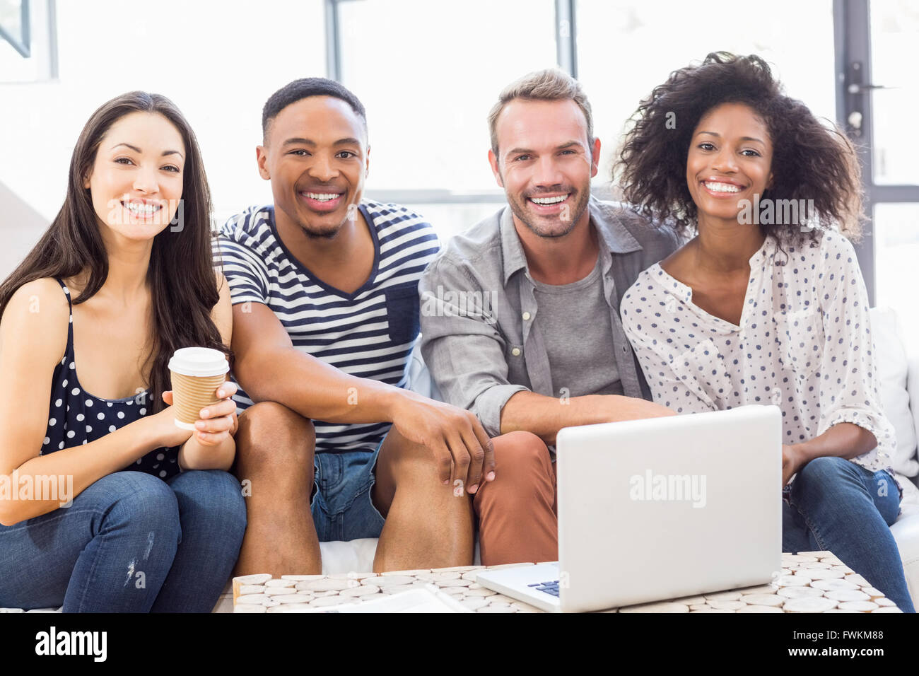 Friends sitting together on sofa Stock Photo - Alamy