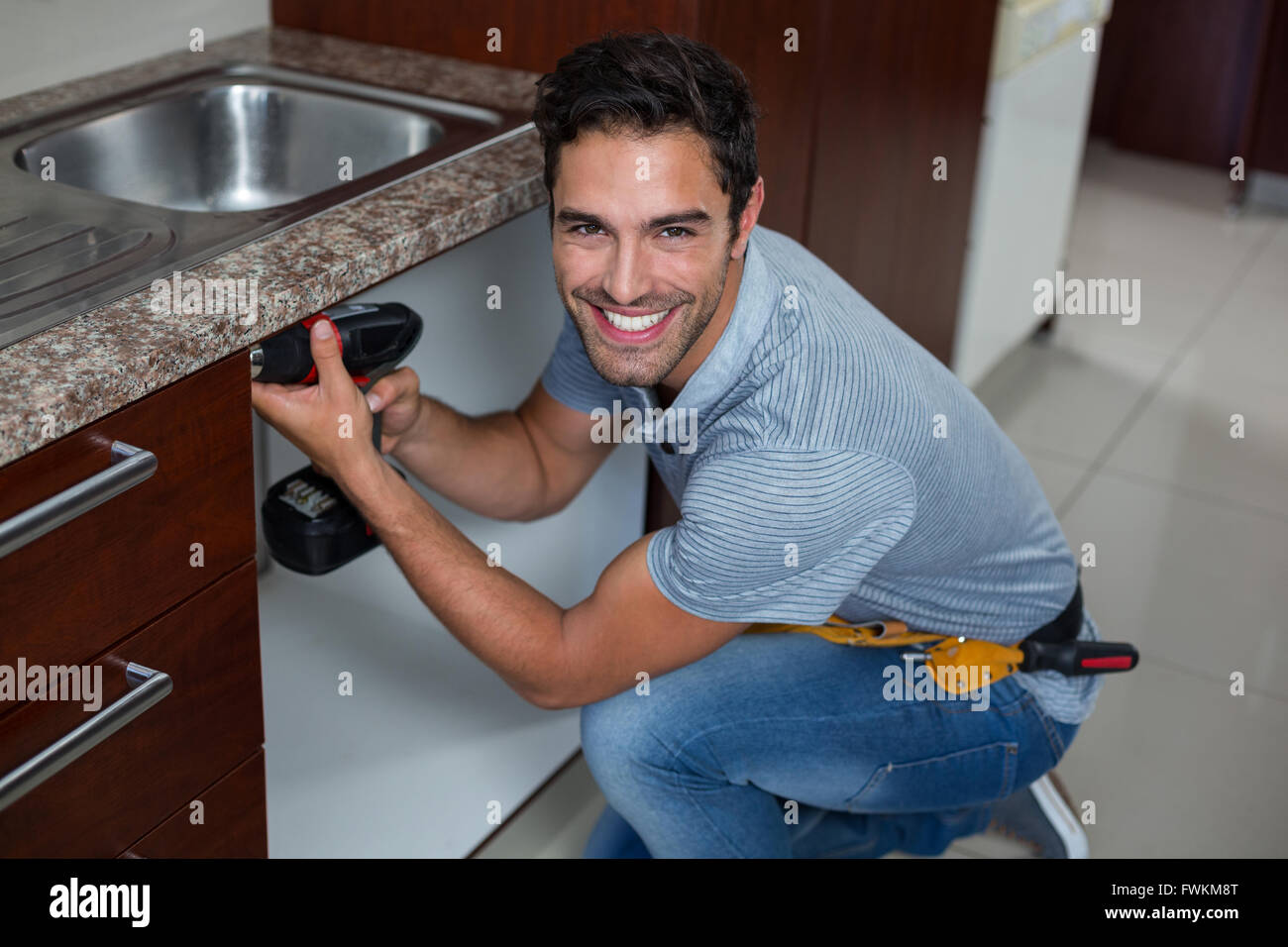 Portrait of cheerful man using cordless hand drill Stock Photo - Alamy