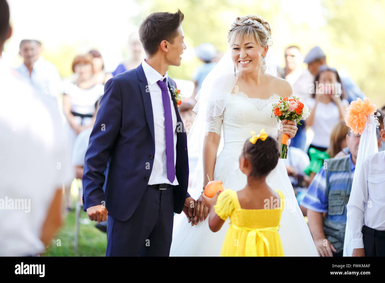 Happy emotional bride during wedding ceremony among guests outdoors ...