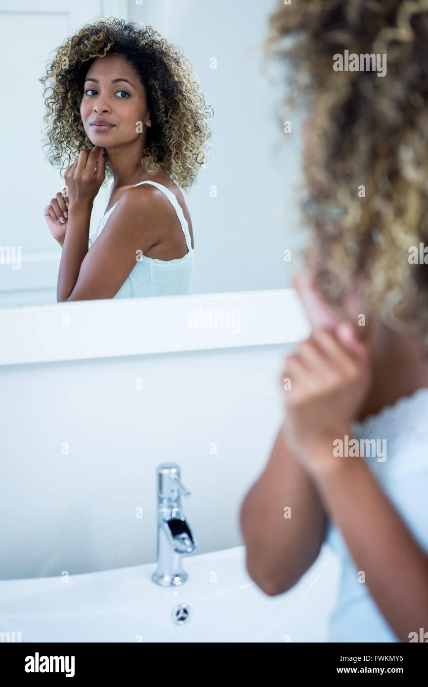 Woman looking in mirror Stock Photo - Alamy