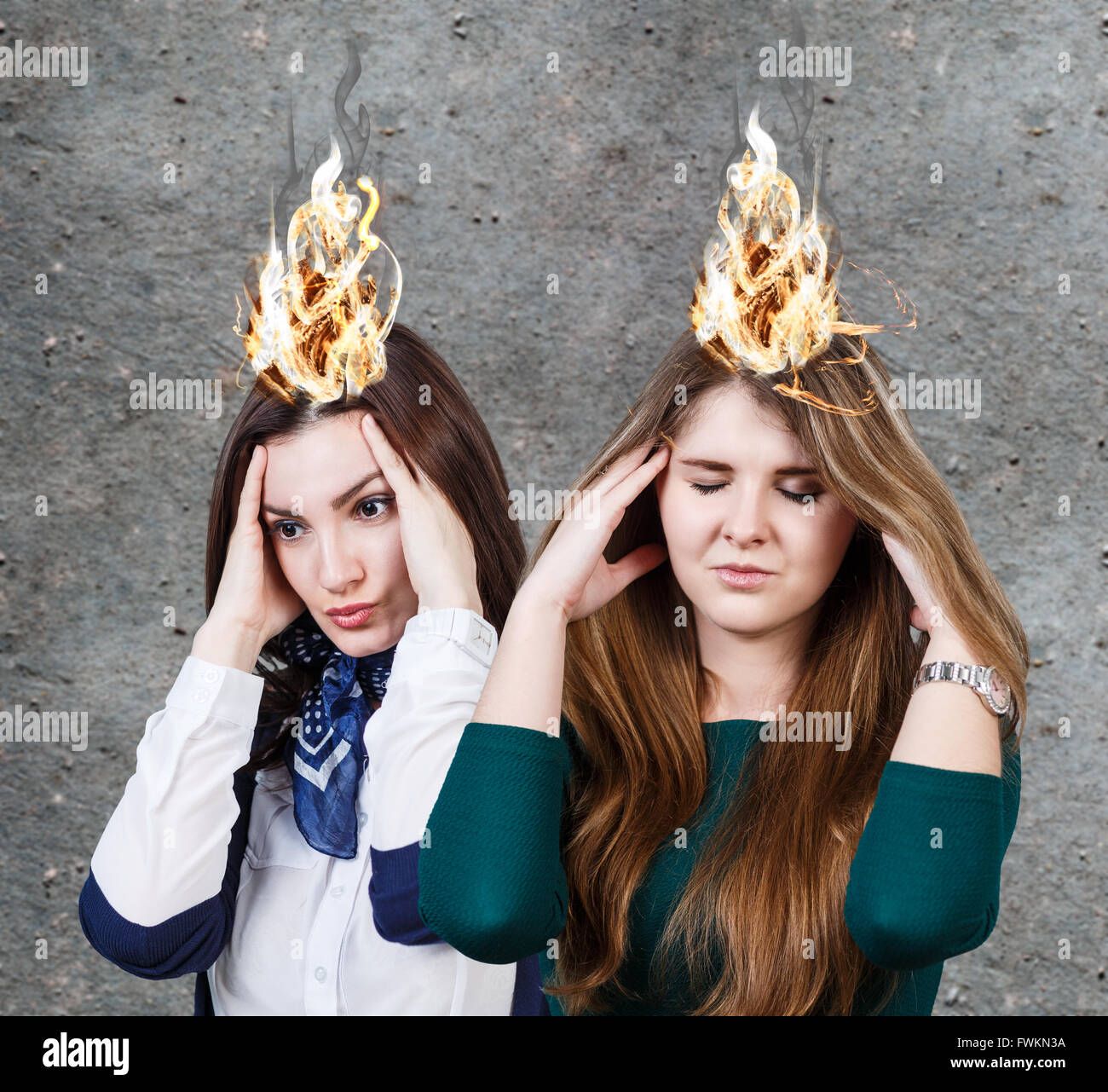 Two women with a strong headache on the gray wall background Stock ...