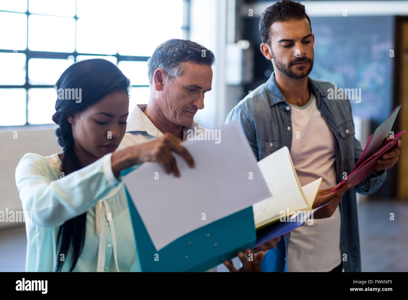 Colleagues looking at file Stock Photo - Alamy