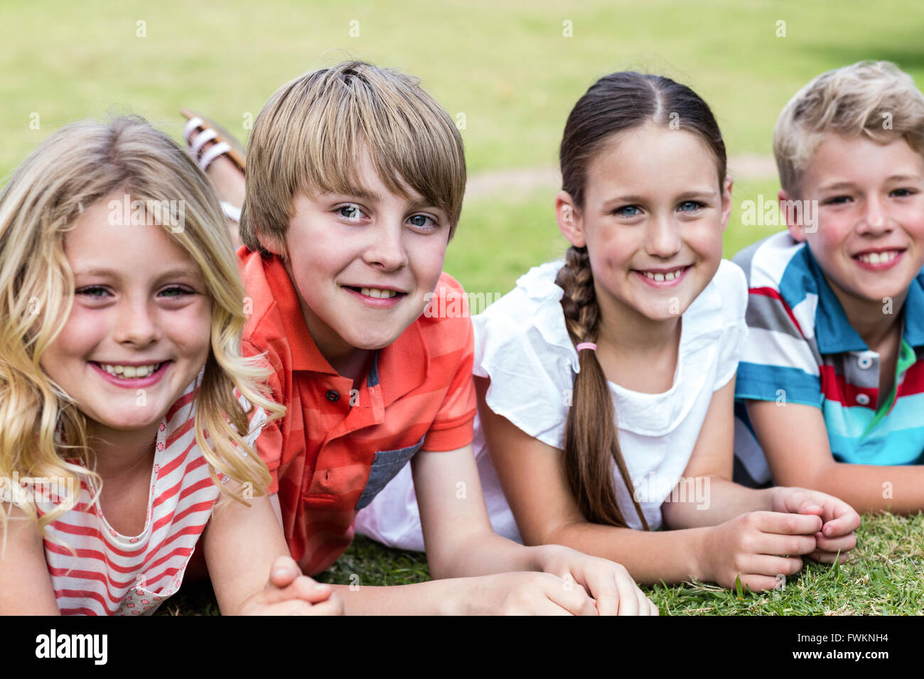 Happy children lying on grass Stock Photo - Alamy