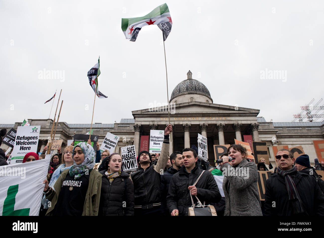 Syrian refugee supporters are waiving Syrian flags during the ...