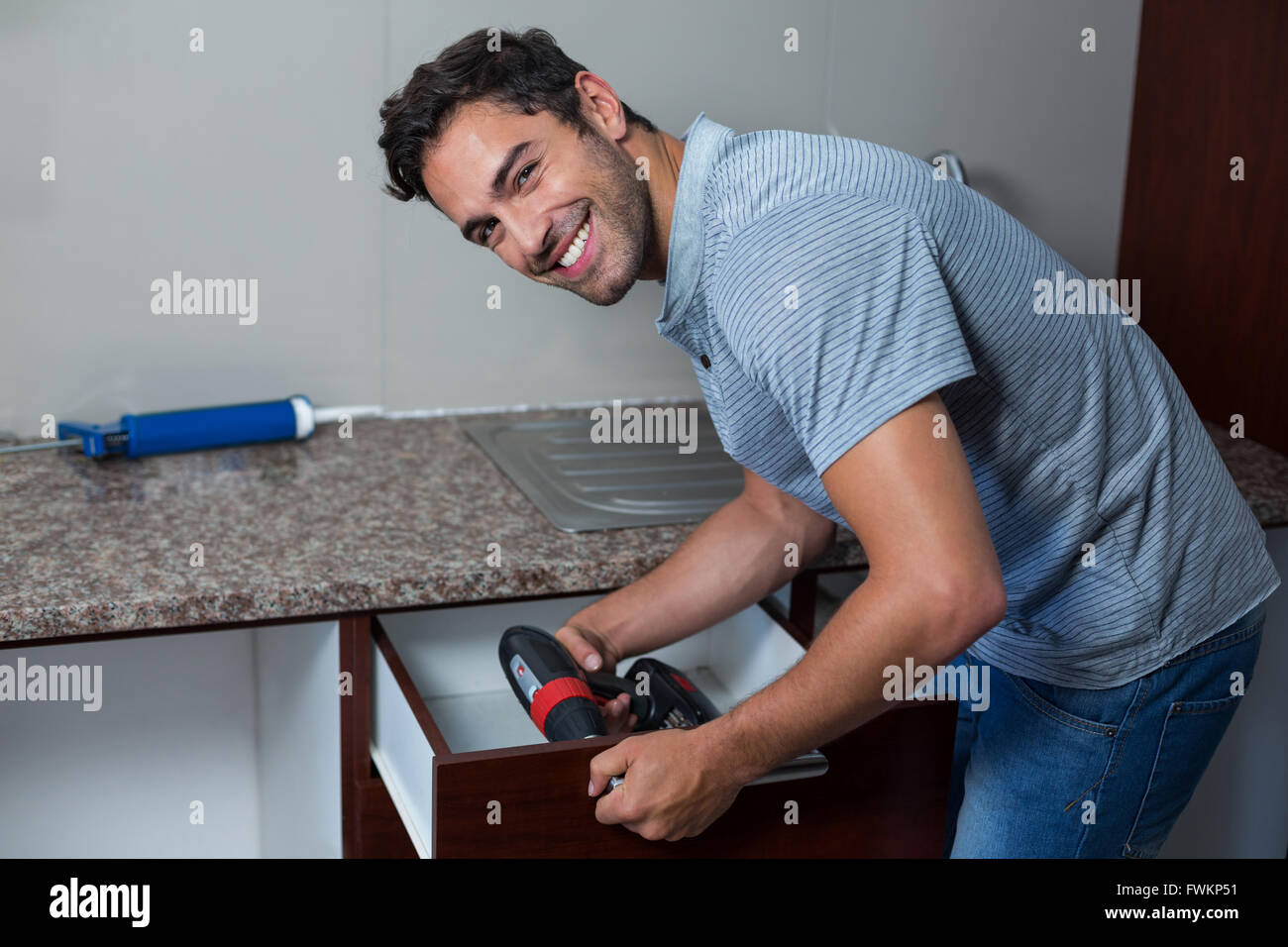Portrait of happy man using cordless hand drill Stock Photo - Alamy