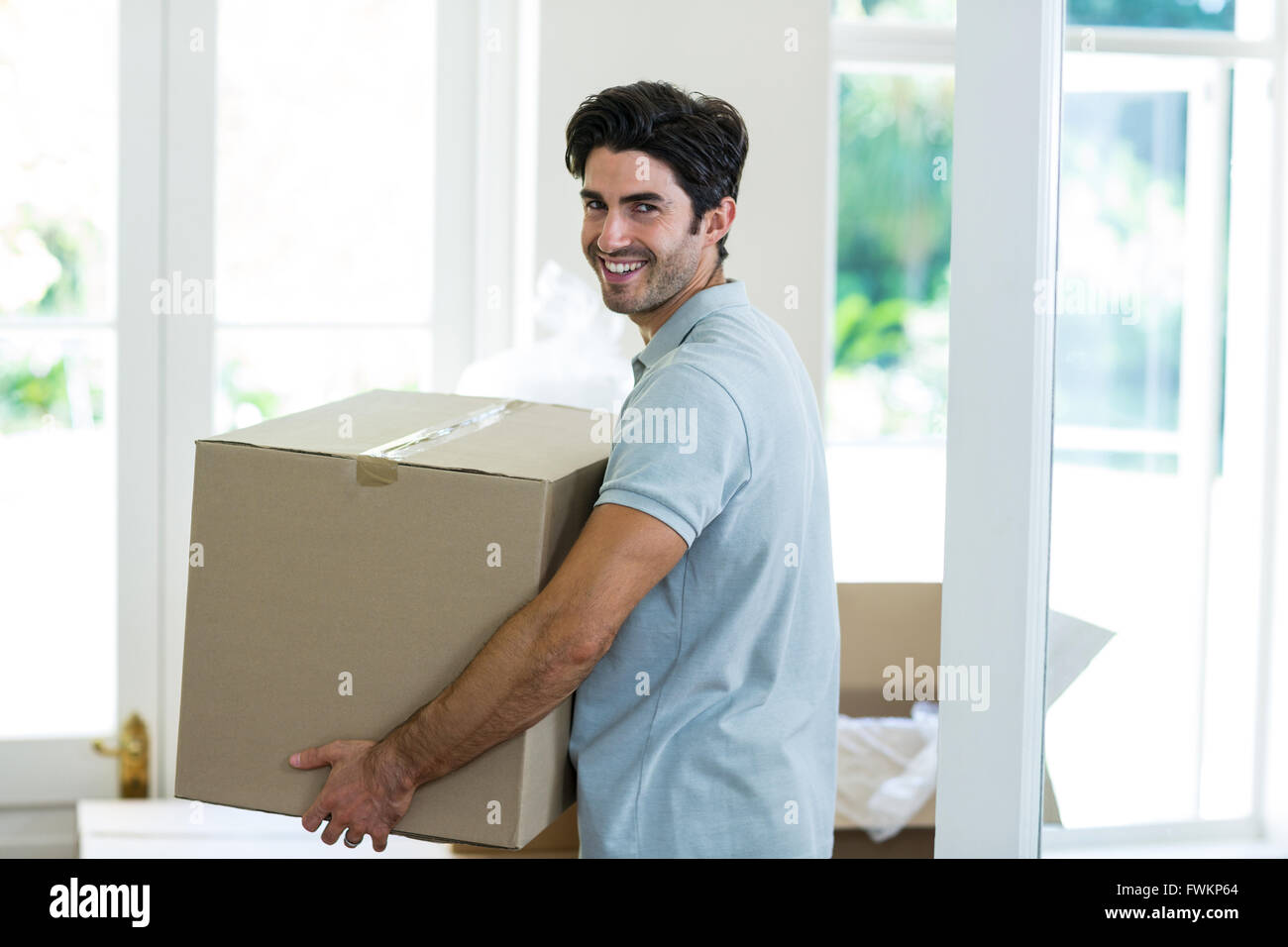 Young man carrying cardboard box Stock Photo - Alamy