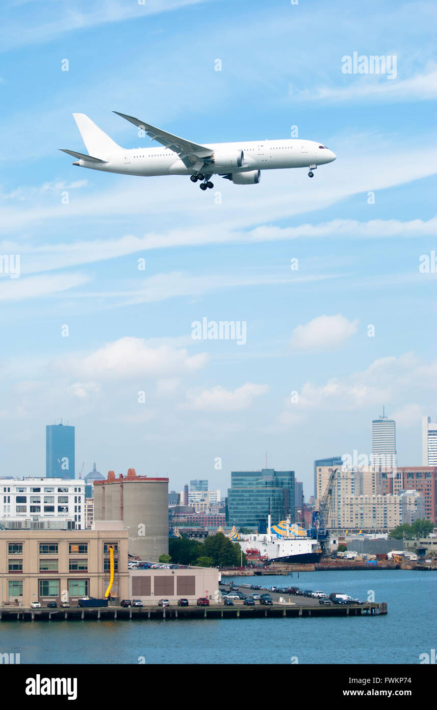 The huge plane is flying over Boston downtown towards the airport ...
