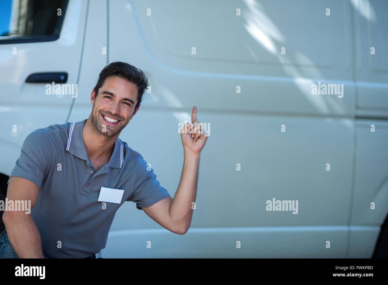 Smiling delivery man pointing van hi-res stock photography and images ...