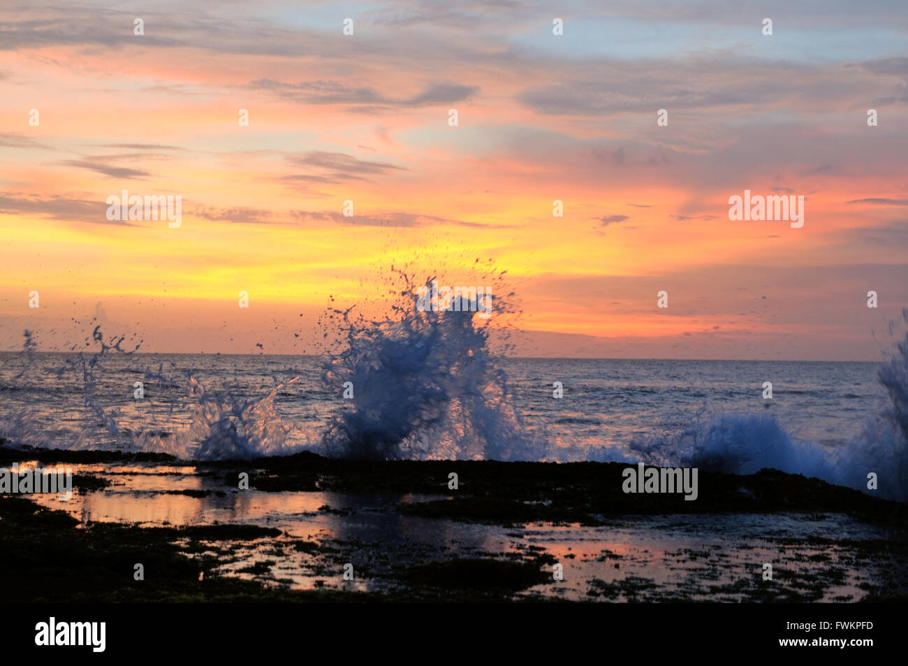 Splashing waves in sunset, Bali, Indonesia Stock Photo - Alamy