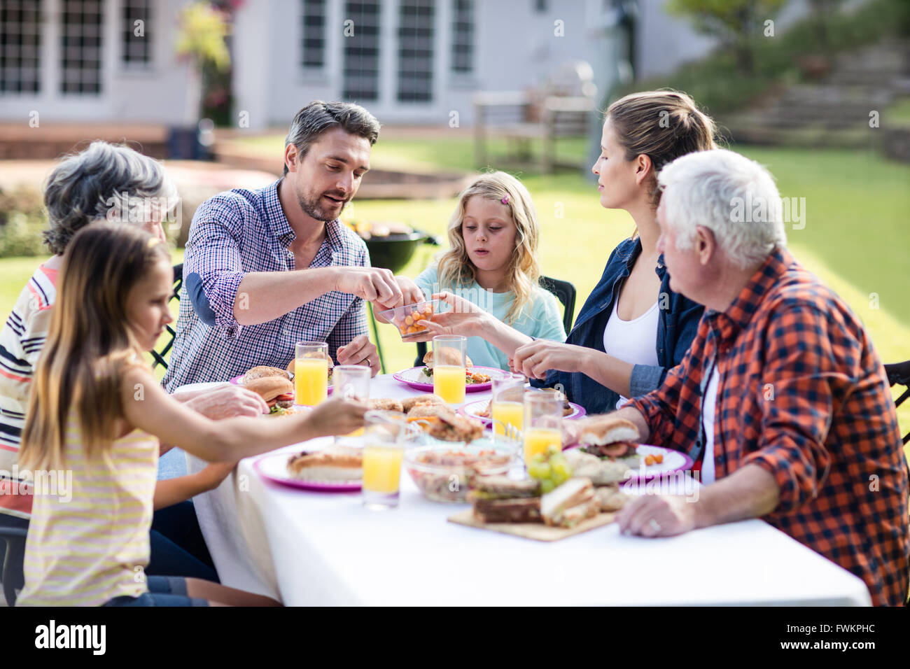 Happy family having lunch in the garden Stock Photo - Alamy
