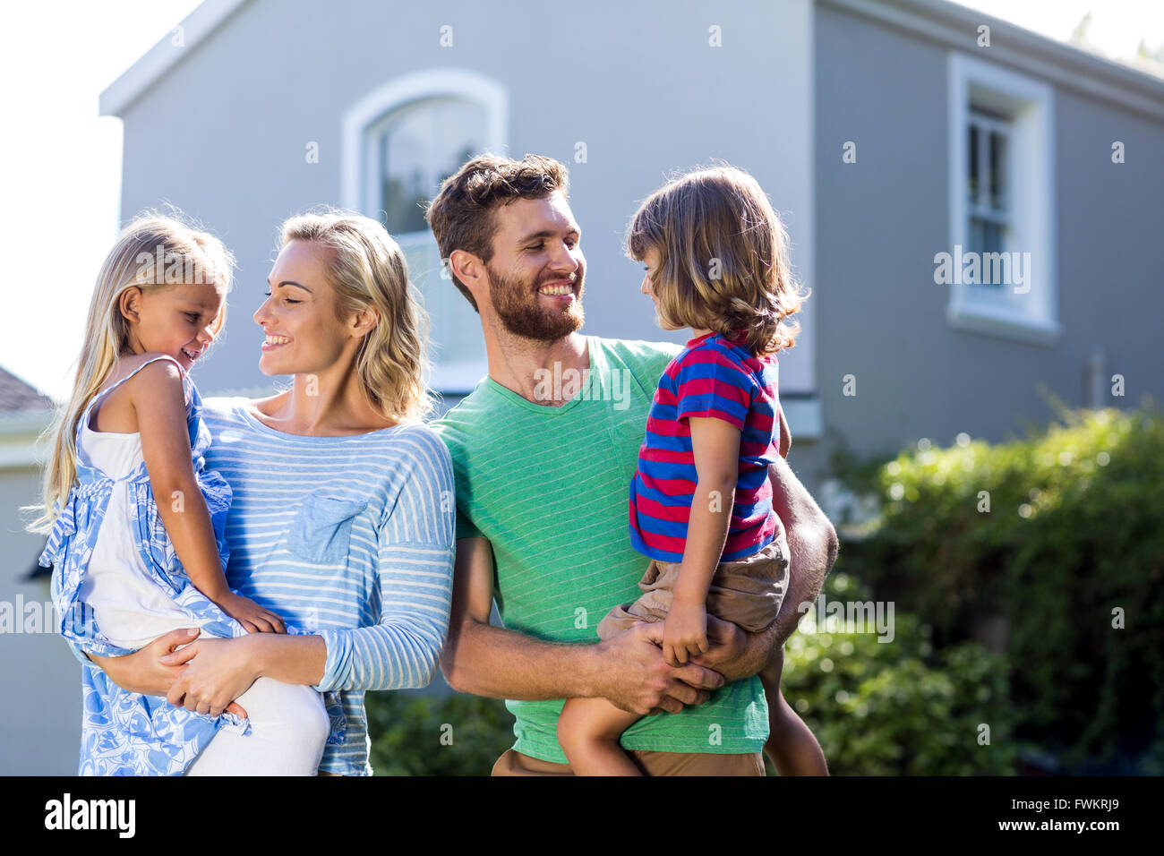 Parents carrying children in yard Stock Photo - Alamy