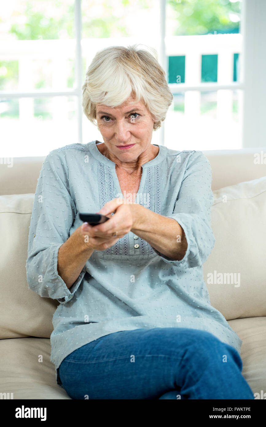 Senior woman operating remote control Stock Photo - Alamy