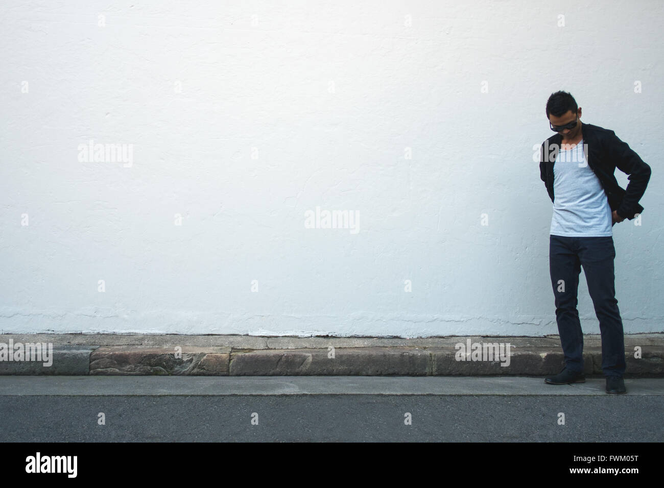 Man standing wall sidewalk hi-res stock photography and images - Alamy