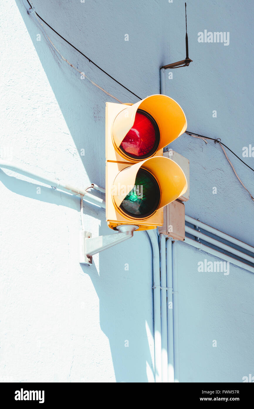 Yellow Traffic light with red and green lights attached to a pastel ...