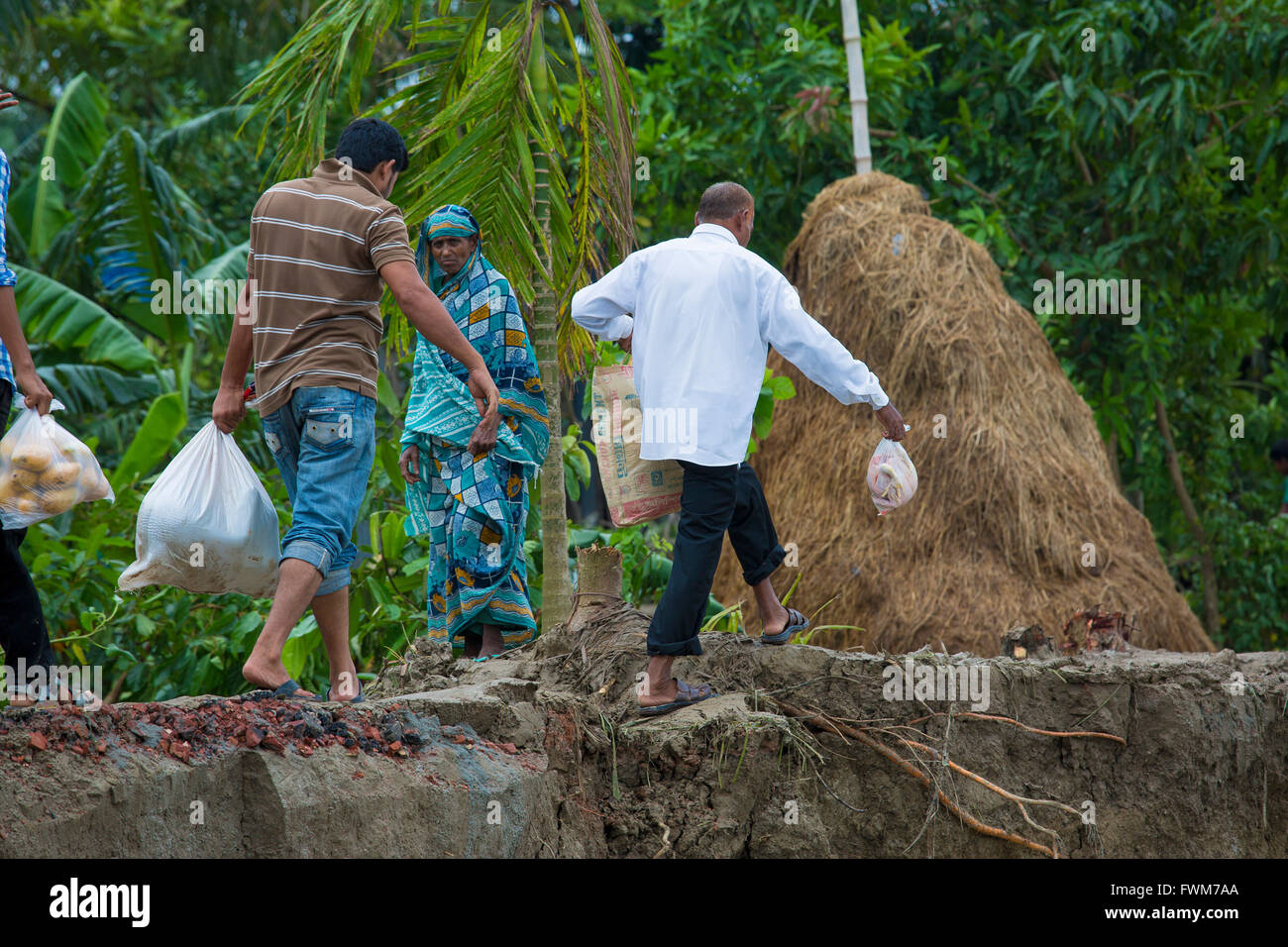 Some people walking by his home at Char areas, Borishal, Bangladesh ...