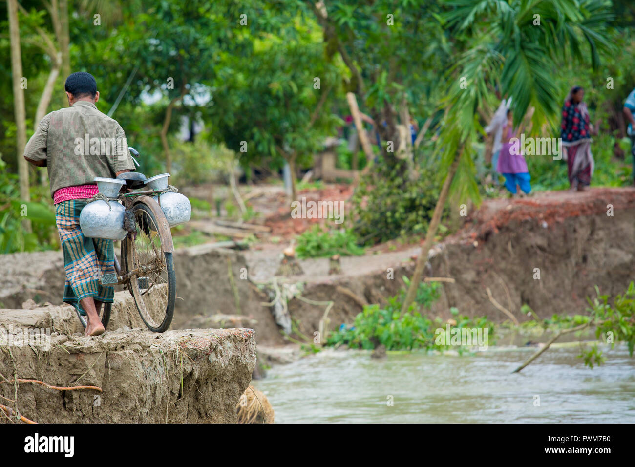 Some people walking by his home at Char areas, Borishal, Bangladesh ...