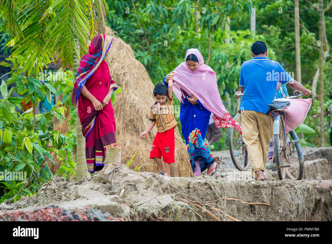 Some people walking by his home at Char areas, Borishal, Bangladesh ...