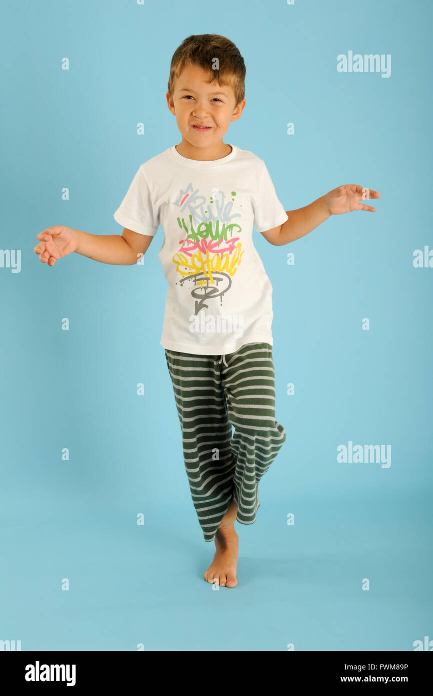 Boy in balance on one foot on blue background Stock Photo - Alamy