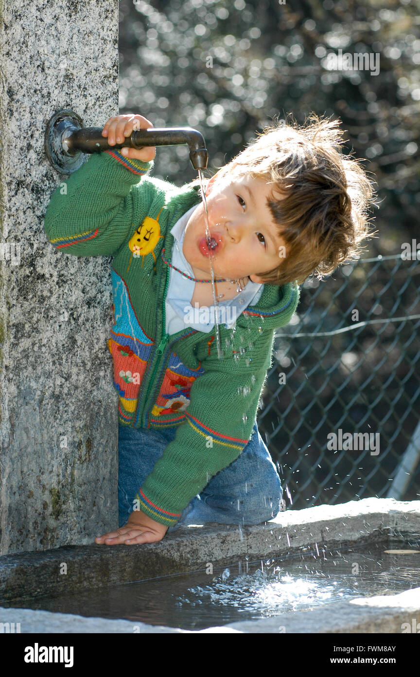 A little boy drinking from a water fountain in the park Stock Photo - Alamy