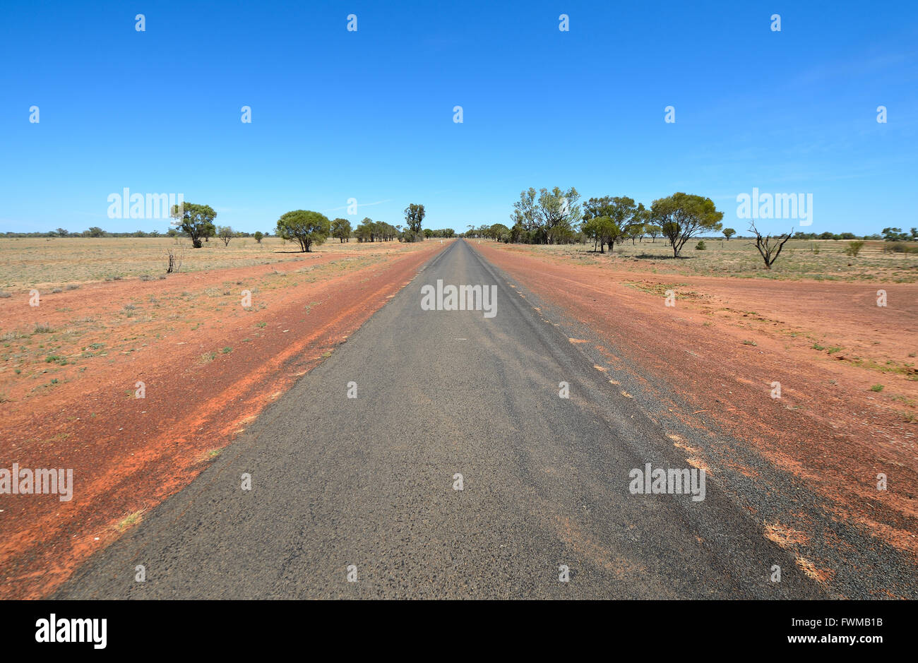 Outback single lane road with red soil and blue sky. Photo CHRIS ISON ...