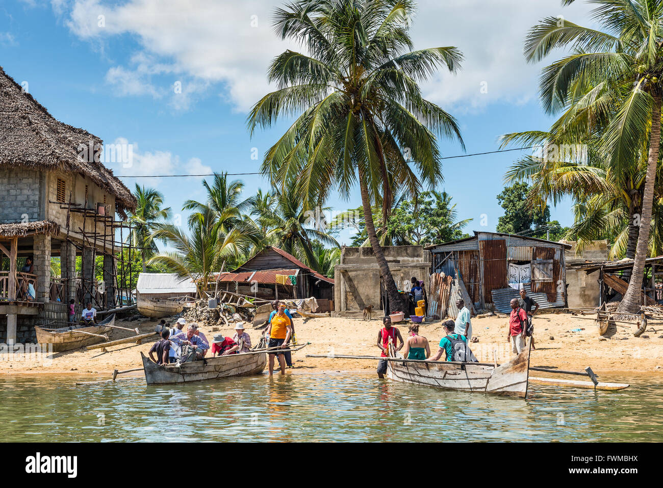 Tourists take places on their traditional wood pirogue with outrigger ...