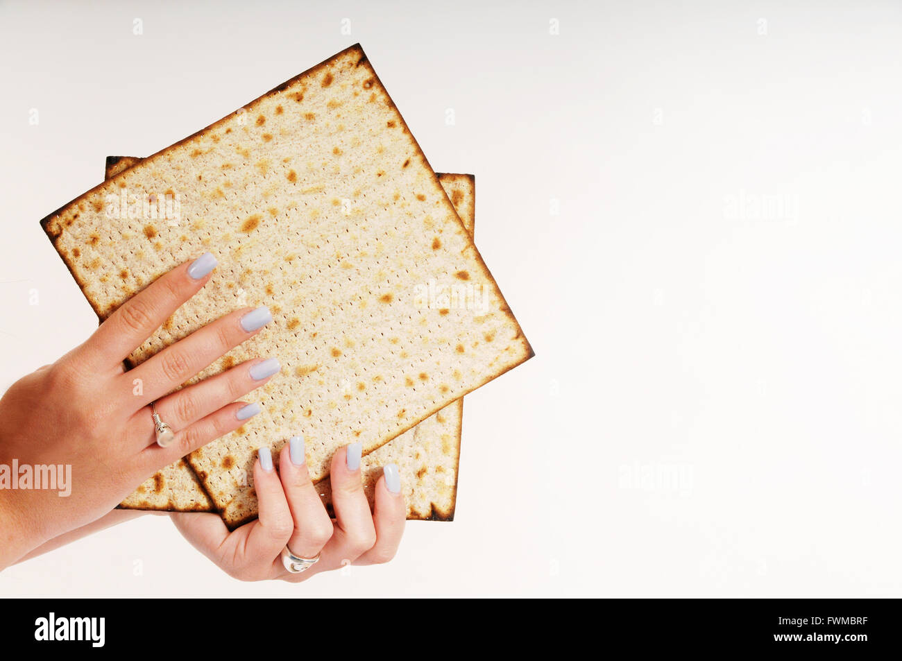 Woman hand with beautiful nails holding two Passover Matzos Stock Photo ...