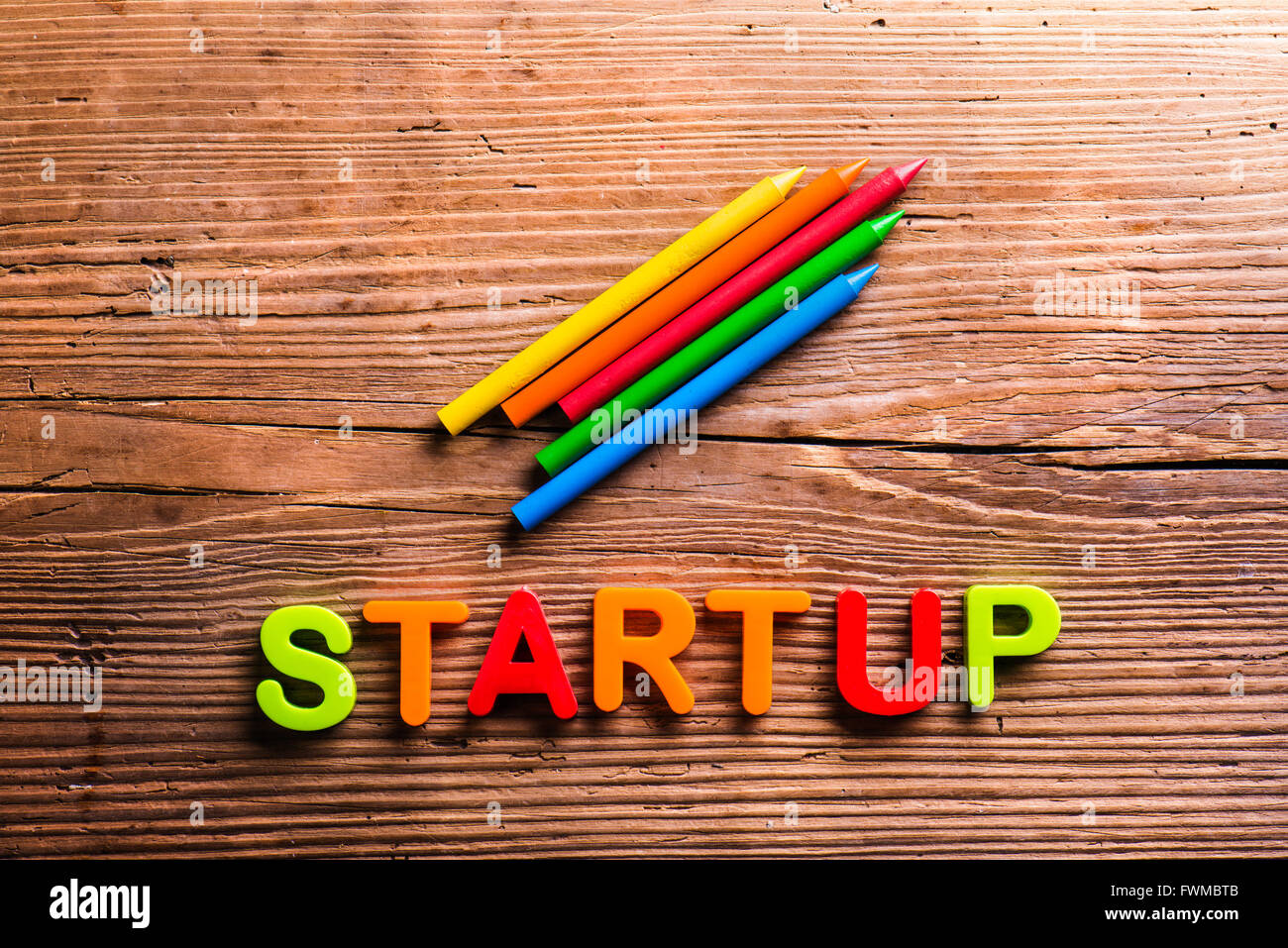 Office desk with start up sign and colorful crayons Stock Photo - Alamy