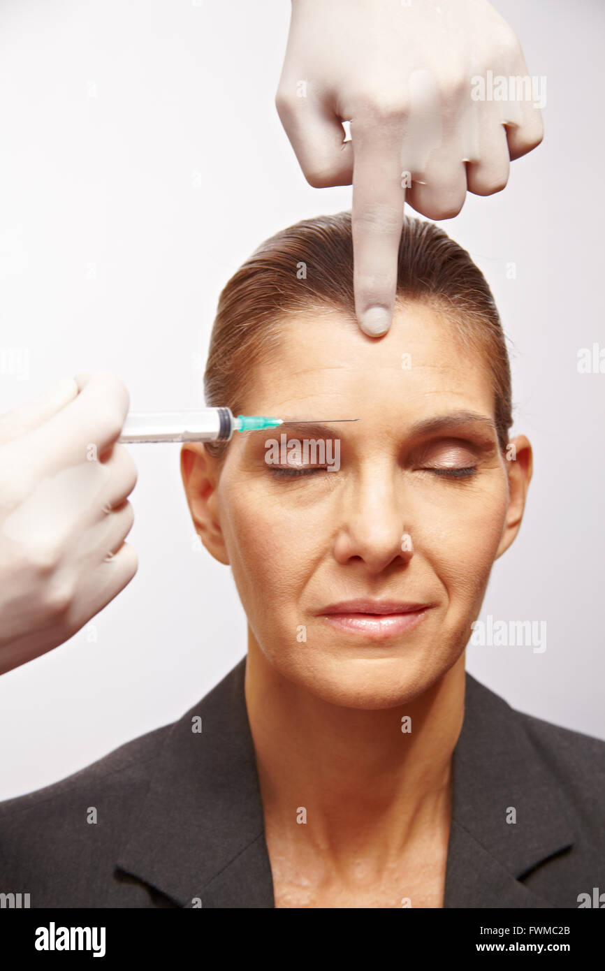 Senior woman getting a syringe injected at plastic surgery Stock Photo ...