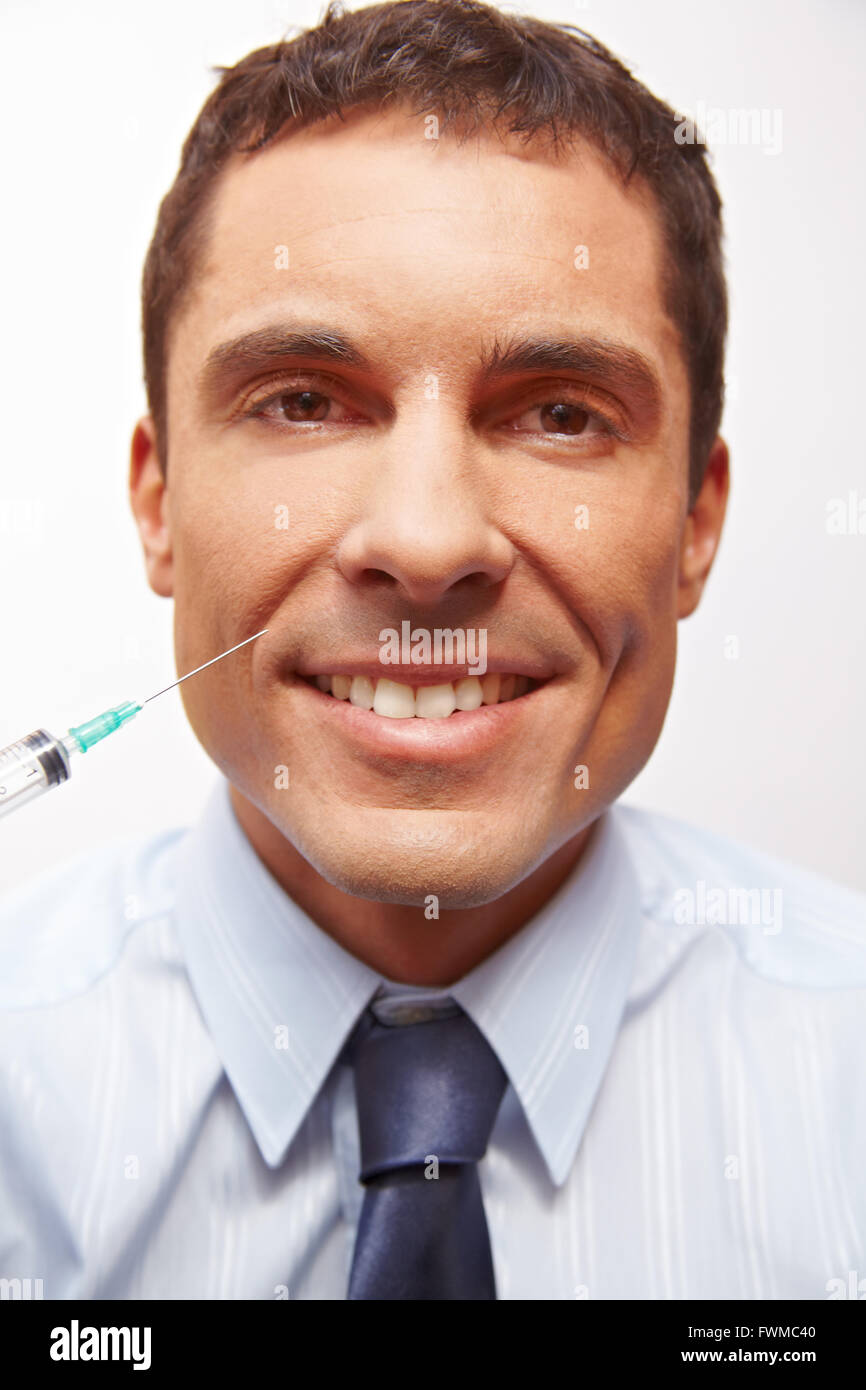 Smiling business man at wrinkle treatment getting needle in corner of ...
