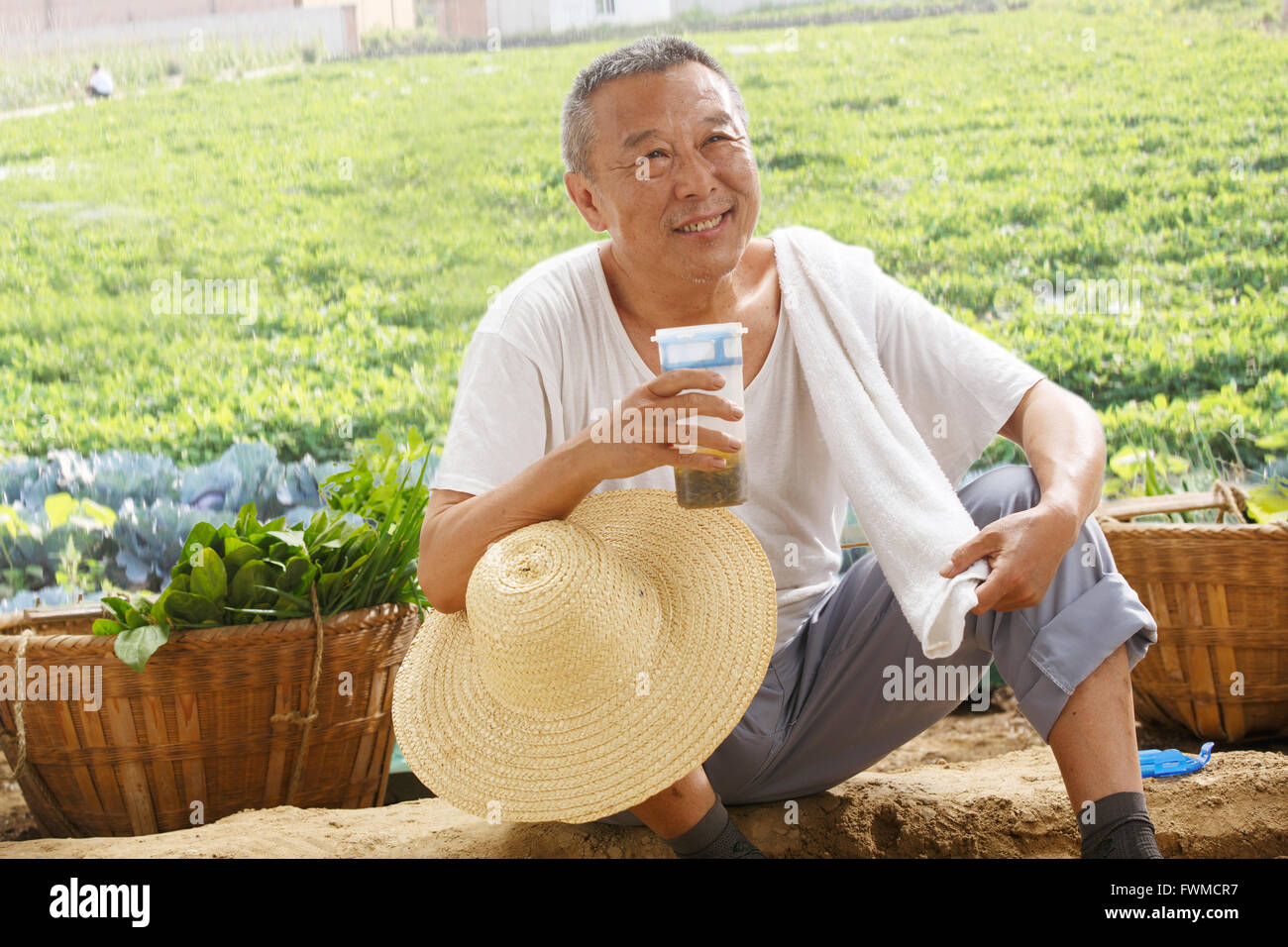 Portrait of farmer resting in field Stock Photo - Alamy