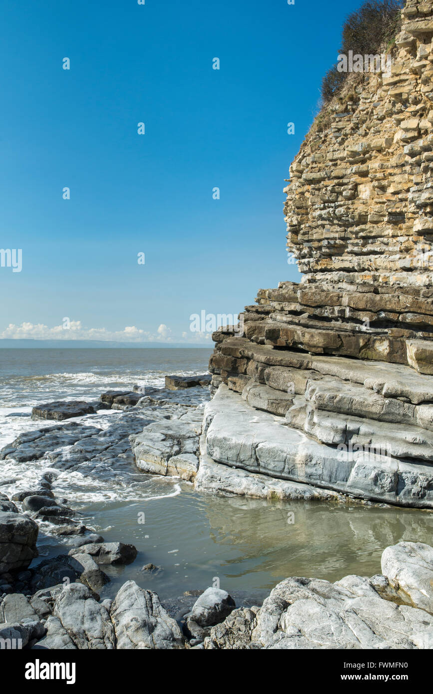 A rock pool below a cliff on a rock beach Stock Photo - Alamy