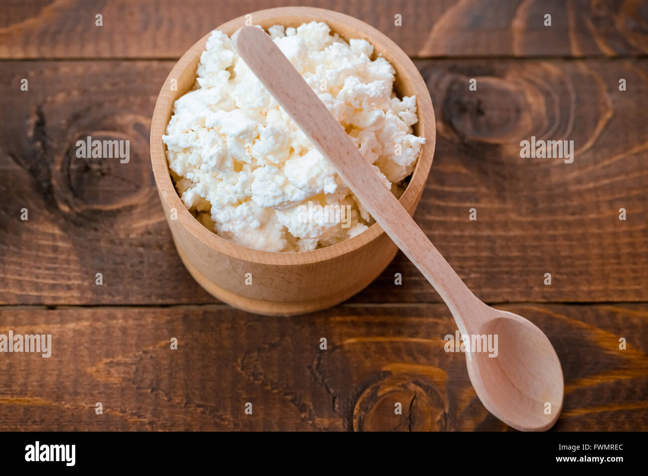 Natural homemade curd in wooden bowl with wooden spoon on brown boards ...