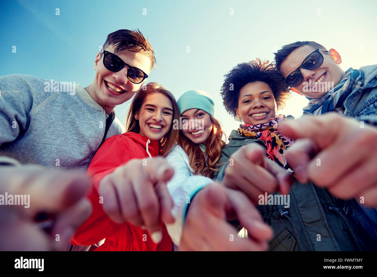 happy teenage friends pointing fingers on street Stock Photo - Alamy