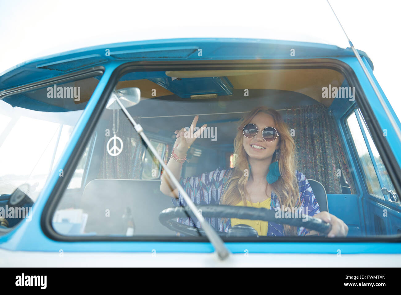 smiling young hippie woman driving minivan car Stock Photo - Alamy