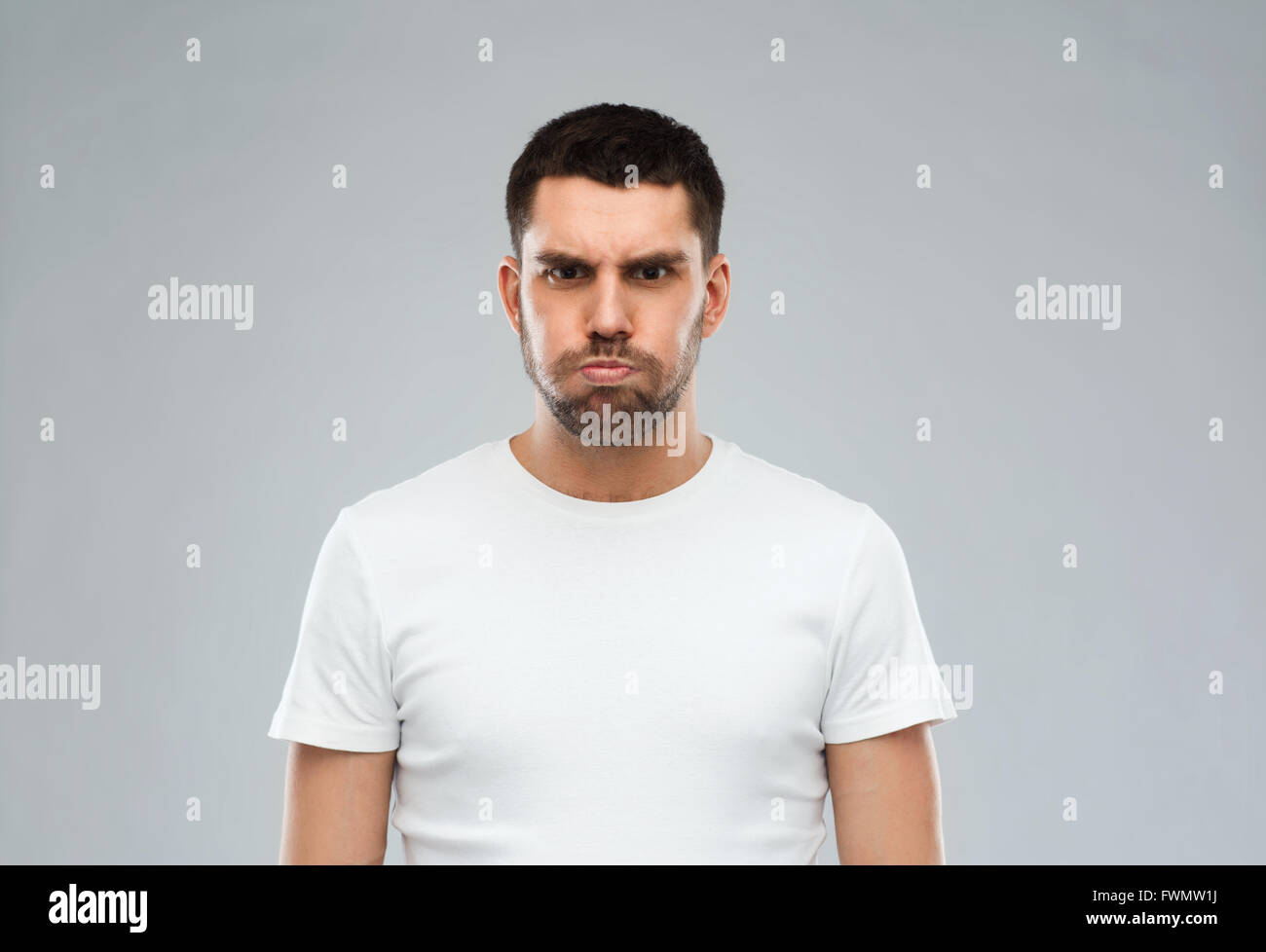 man with funny angry face over gray background Stock Photo - Alamy