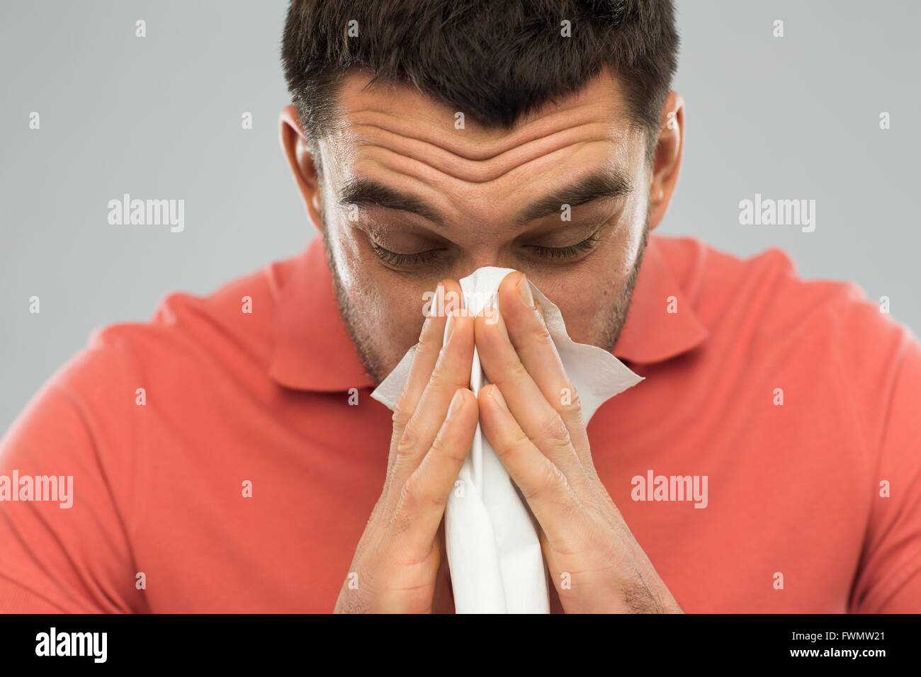 Sick hispanic man blowing nose hi-res stock photography and images - Alamy