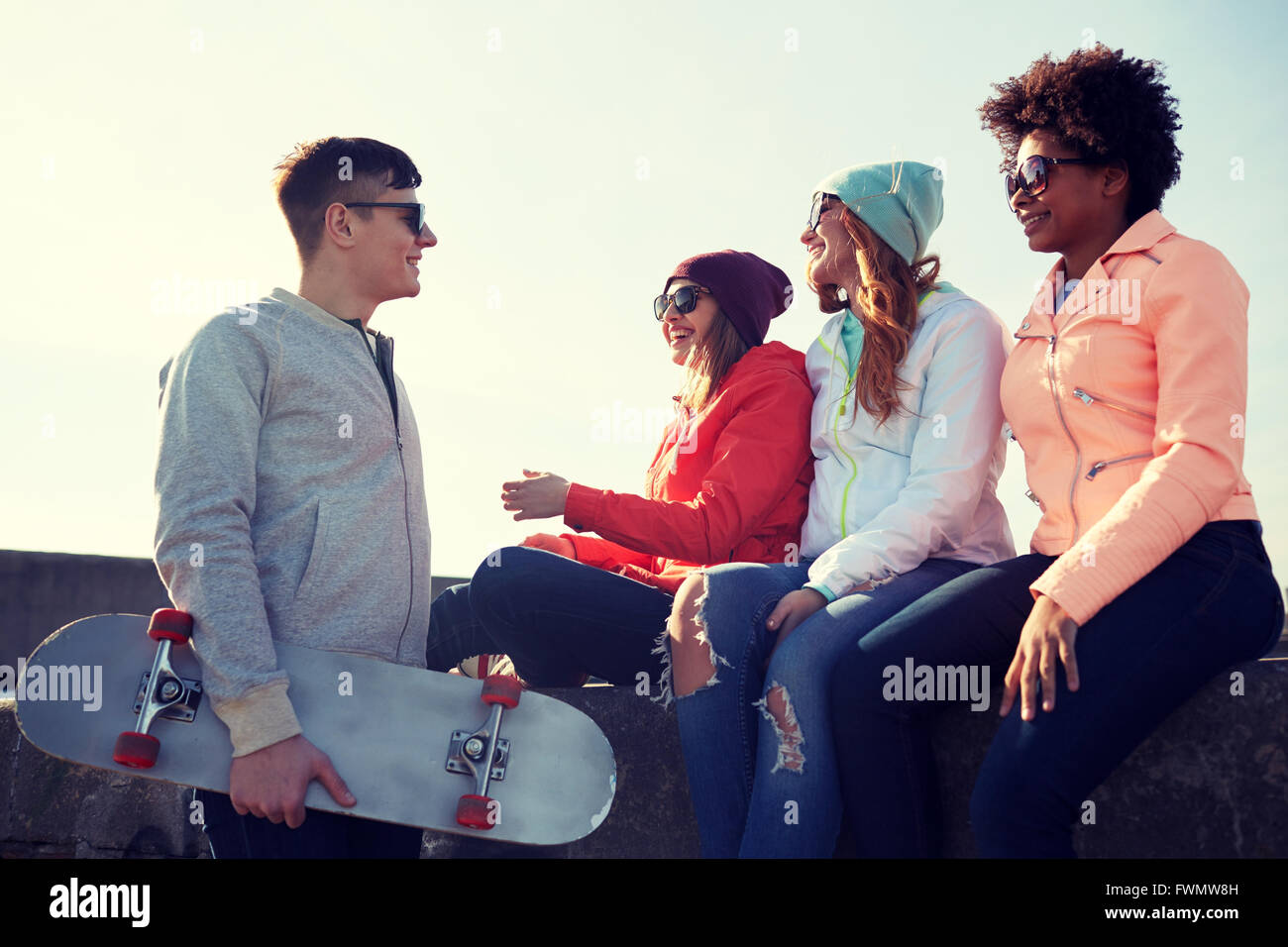 happy teenage friends with longboard on street Stock Photo - Alamy