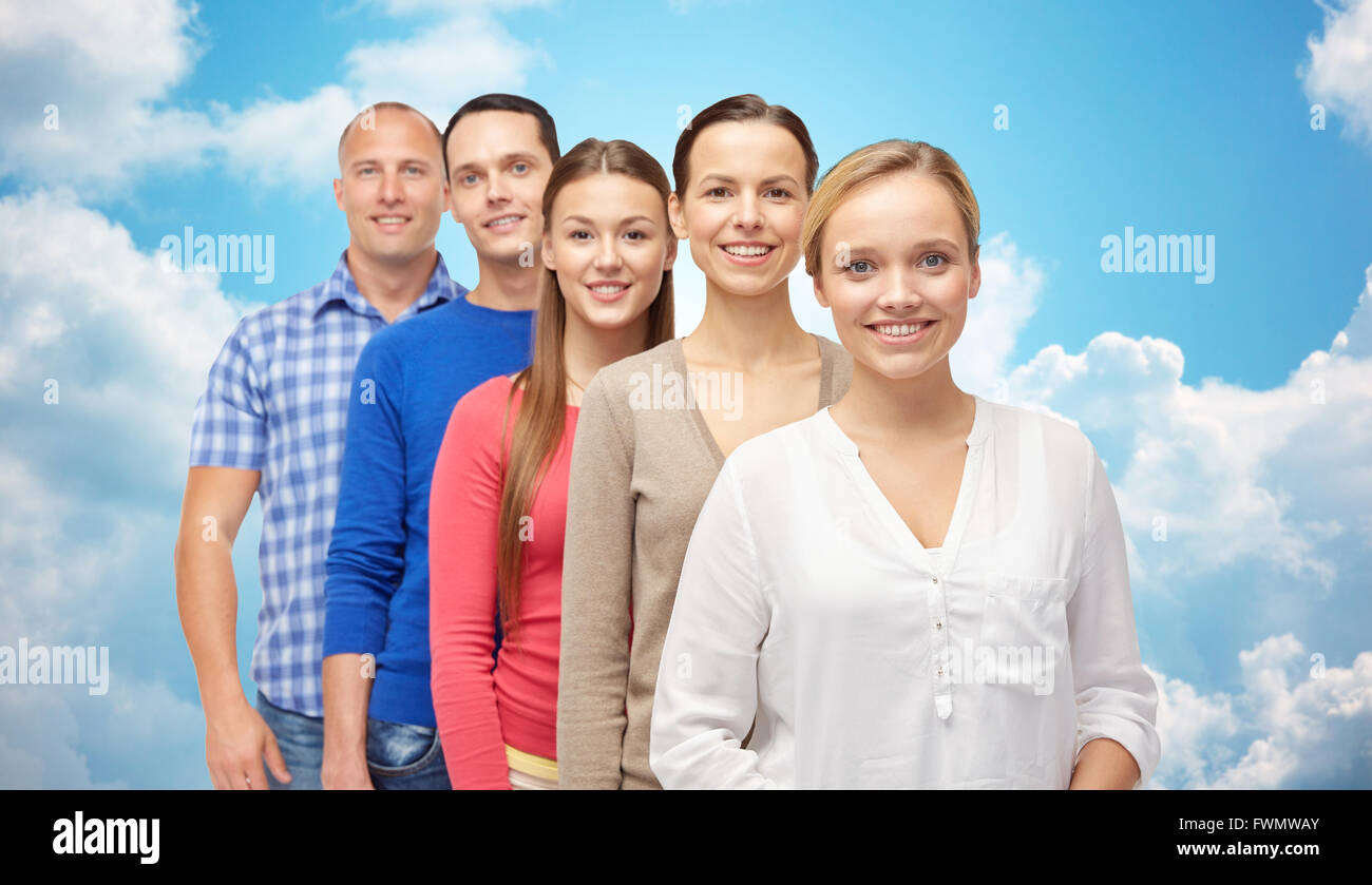 group of smiling people over blue sky and clouds Stock Photo - Alamy