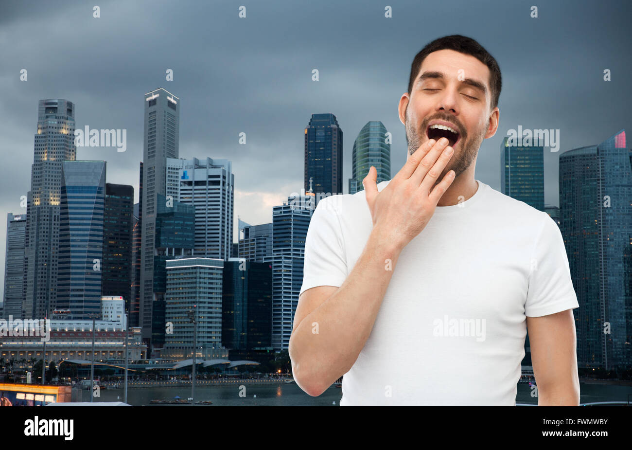 yawning man over evening singapore city background Stock Photo - Alamy
