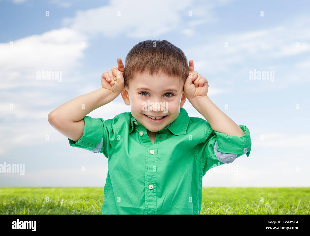 happy little boy having fun and making horns Stock Photo - Alamy
