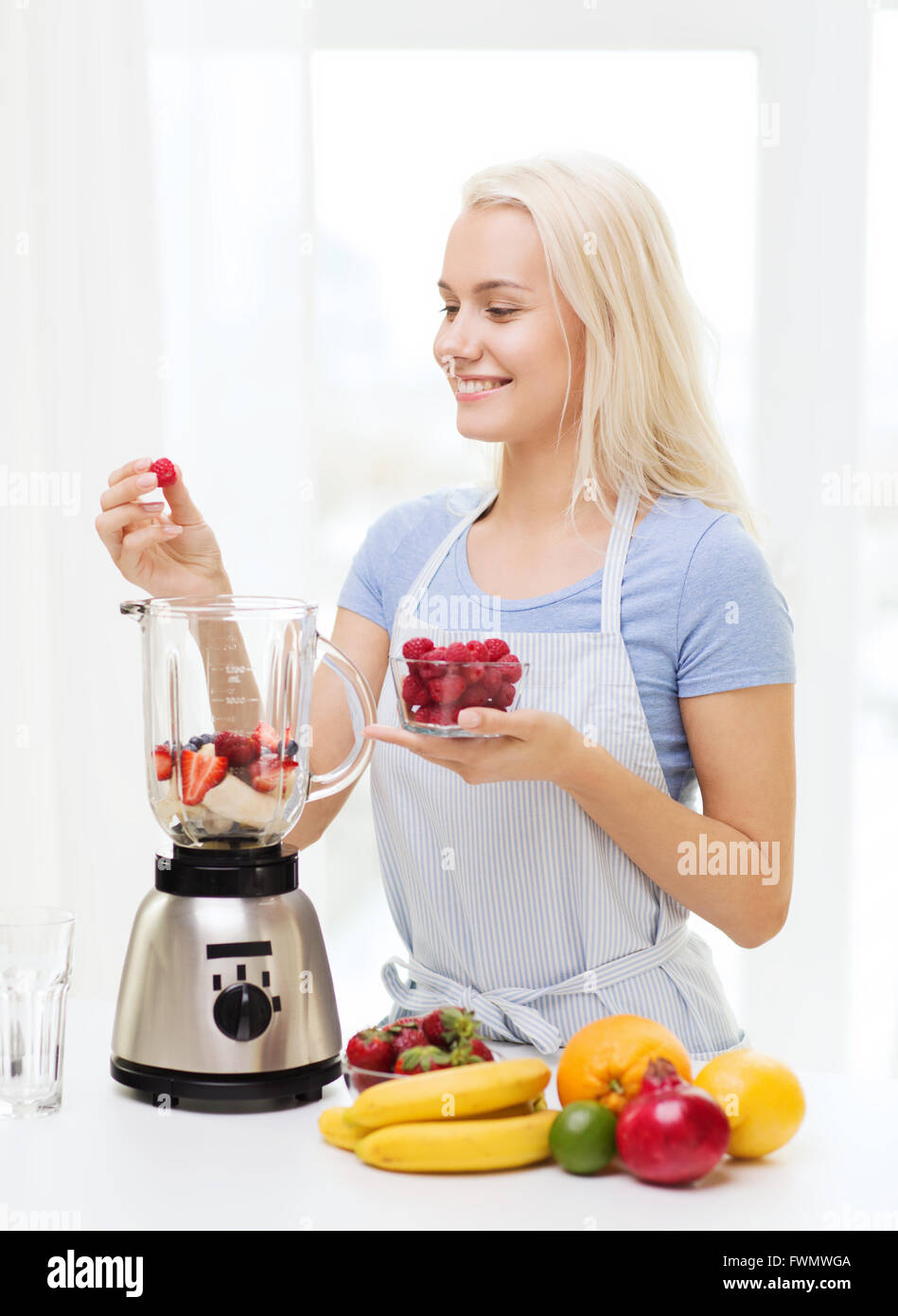 smiling woman with blender preparing shake at home Stock Photo - Alamy