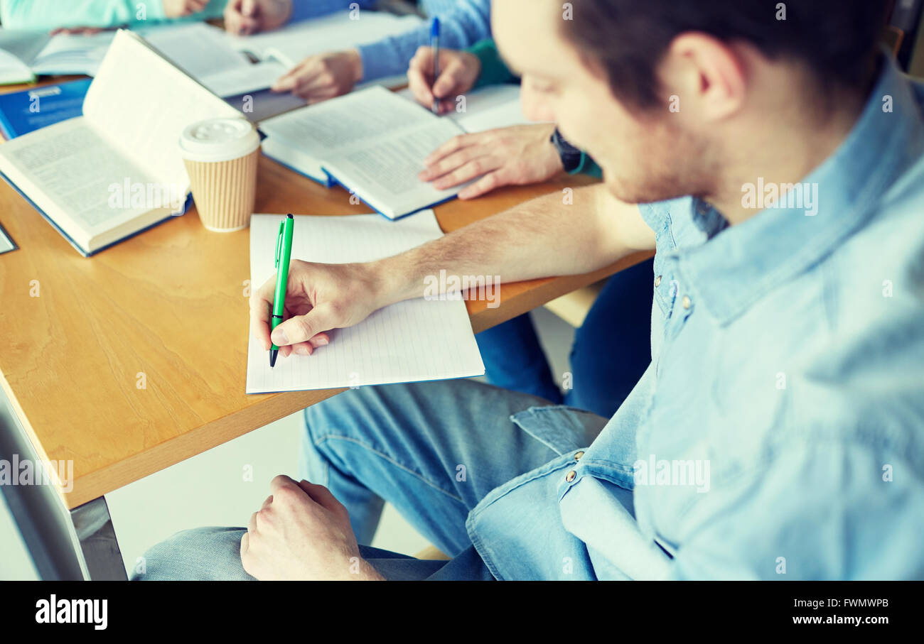 happy students writing to notebooks in library Stock Photo - Alamy