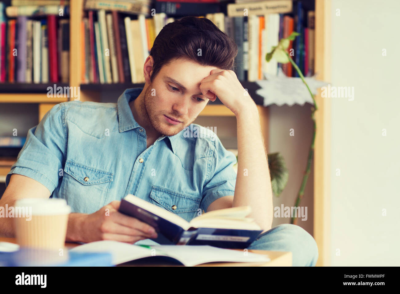 male student reading book in library Stock Photo - Alamy