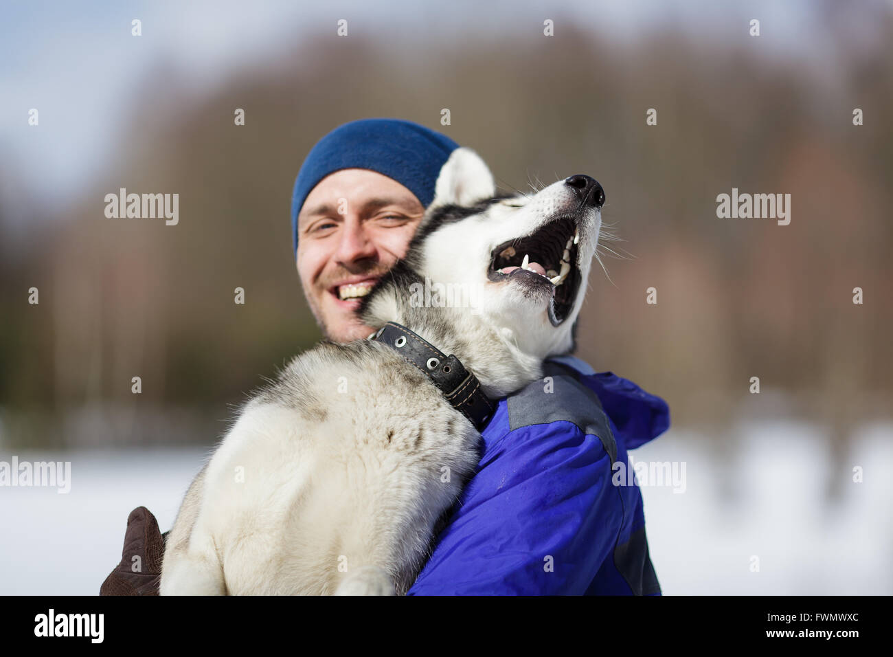 Happy man with a husky at winter time Stock Photo - Alamy