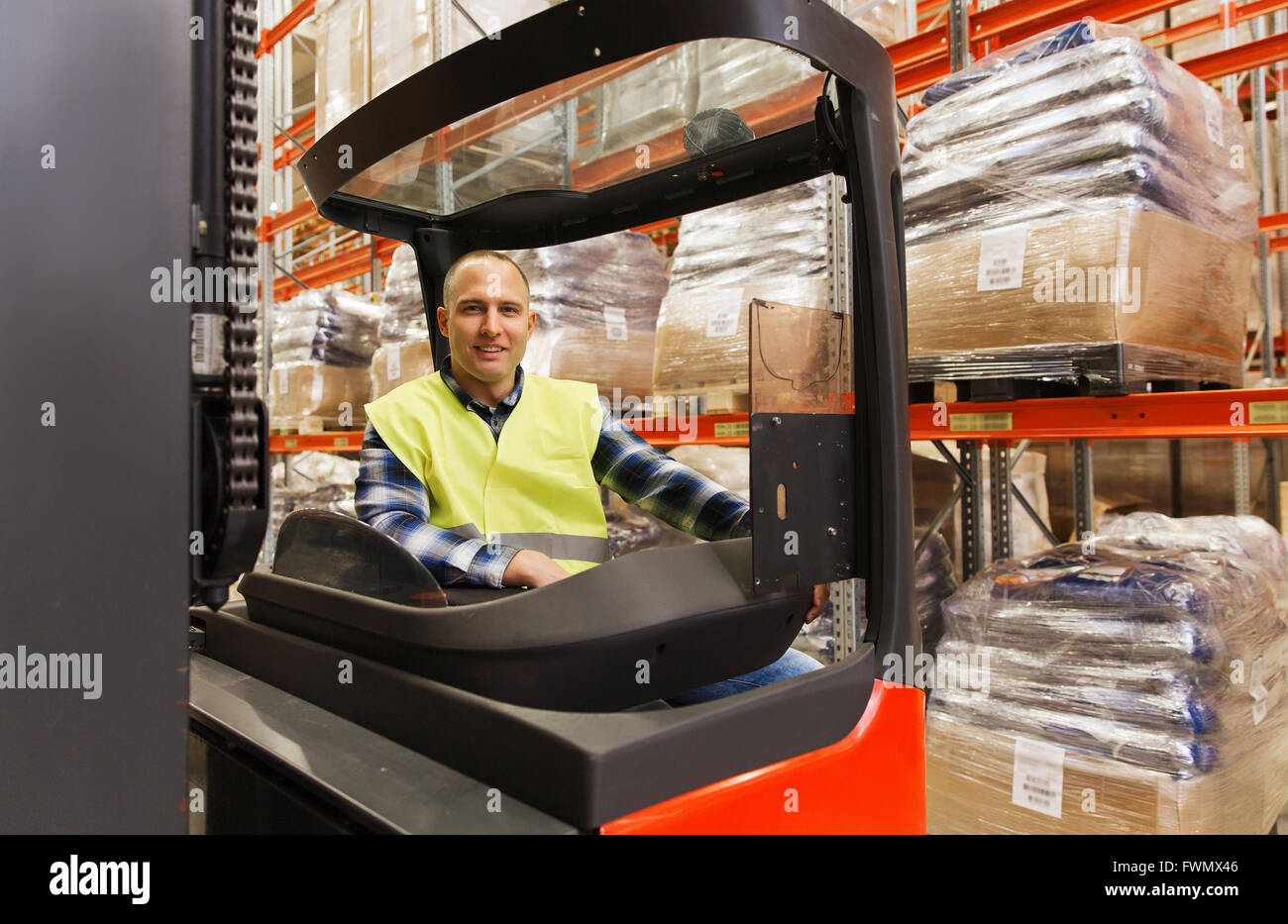 smiling man operating forklift loader at warehouse Stock Photo - Alamy