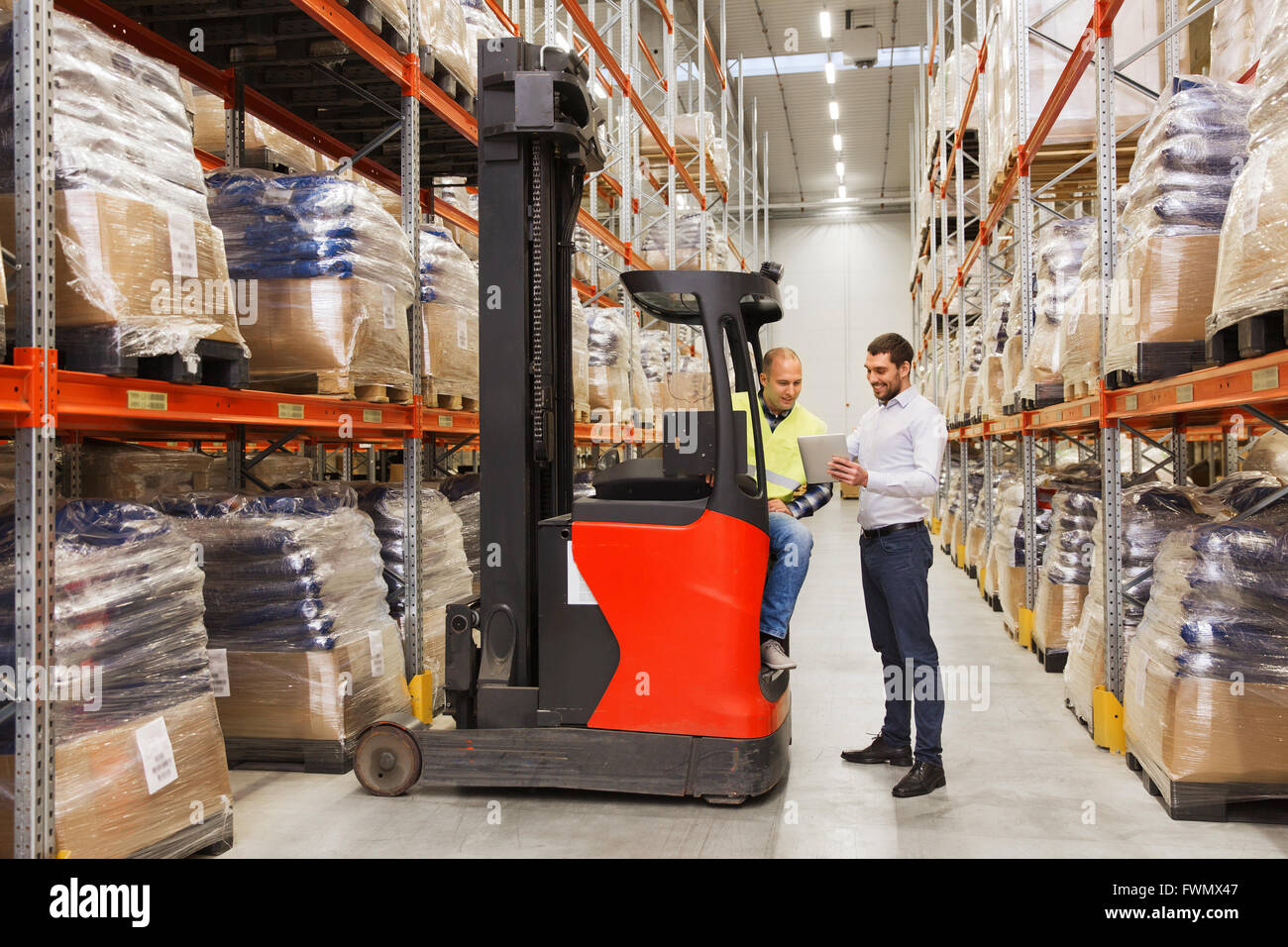 men with tablet pc and forklift at warehouse Stock Photo - Alamy