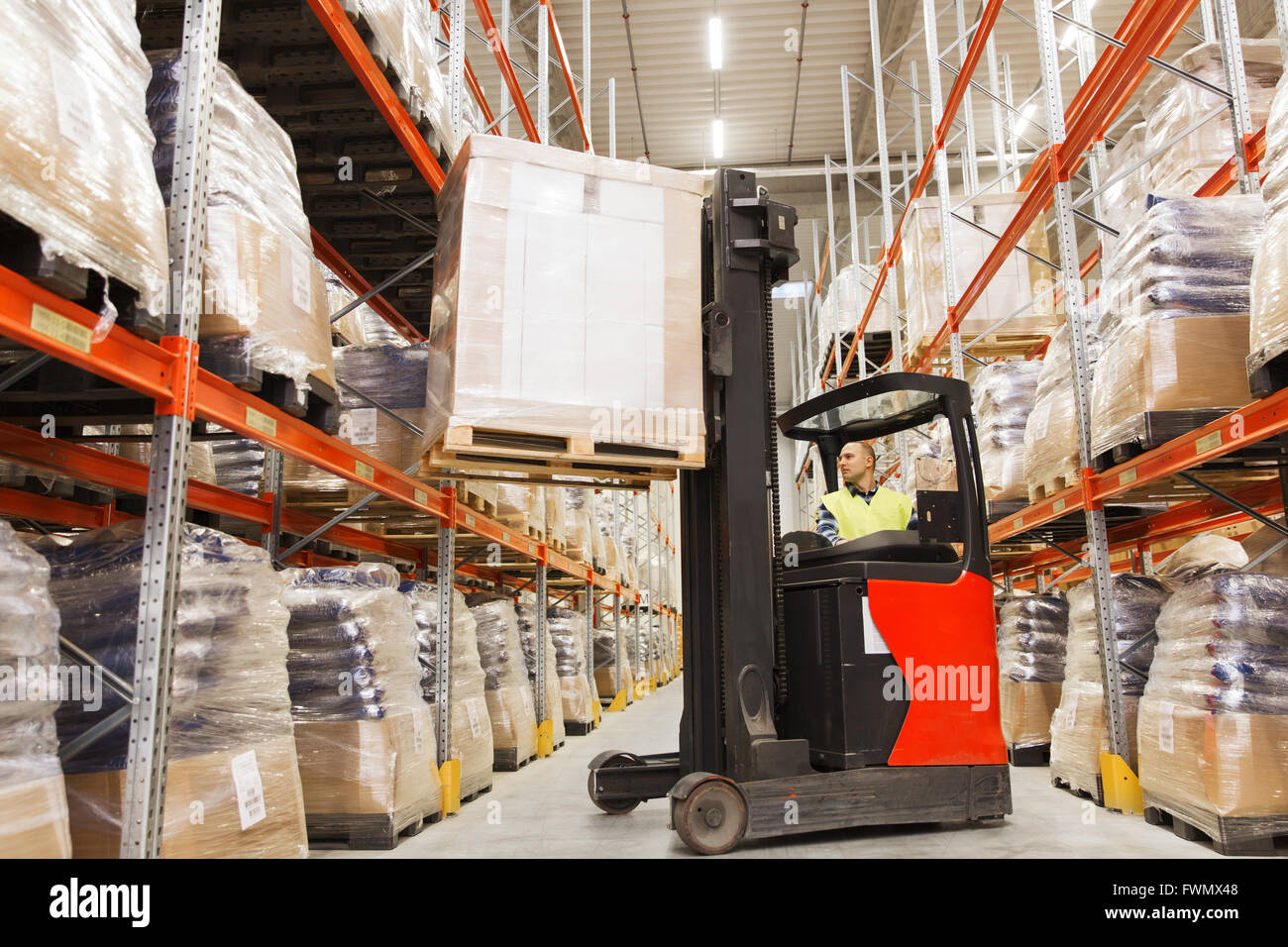 man on forklift loading cargo at warehouse Stock Photo - Alamy