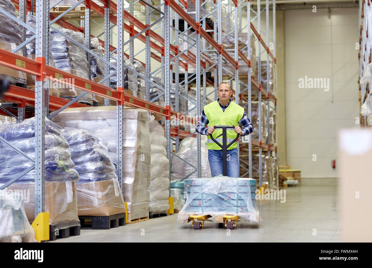 man carrying loader with goods at warehouse Stock Photo - Alamy