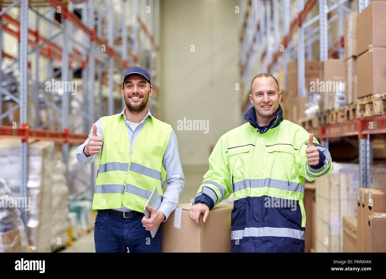 men with boxes showing thumbs up at warehouse Stock Photo - Alamy