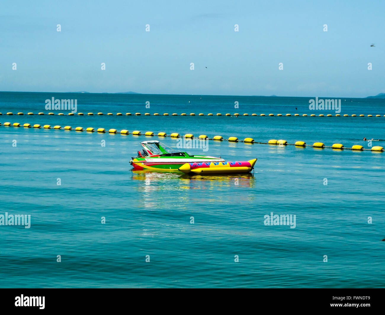 The boat and banana boat near barrier in the sea and blue sky Stock ...